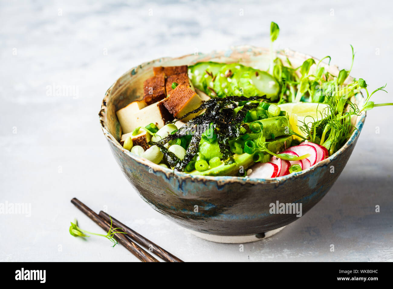 Poke bowl with avocado, black rice, smoked tofu, vegetables, sprouts ...