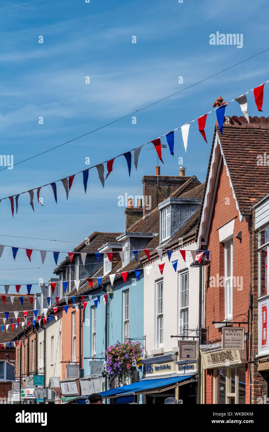 Classic summer English street with brightly coloured shops and houses ...