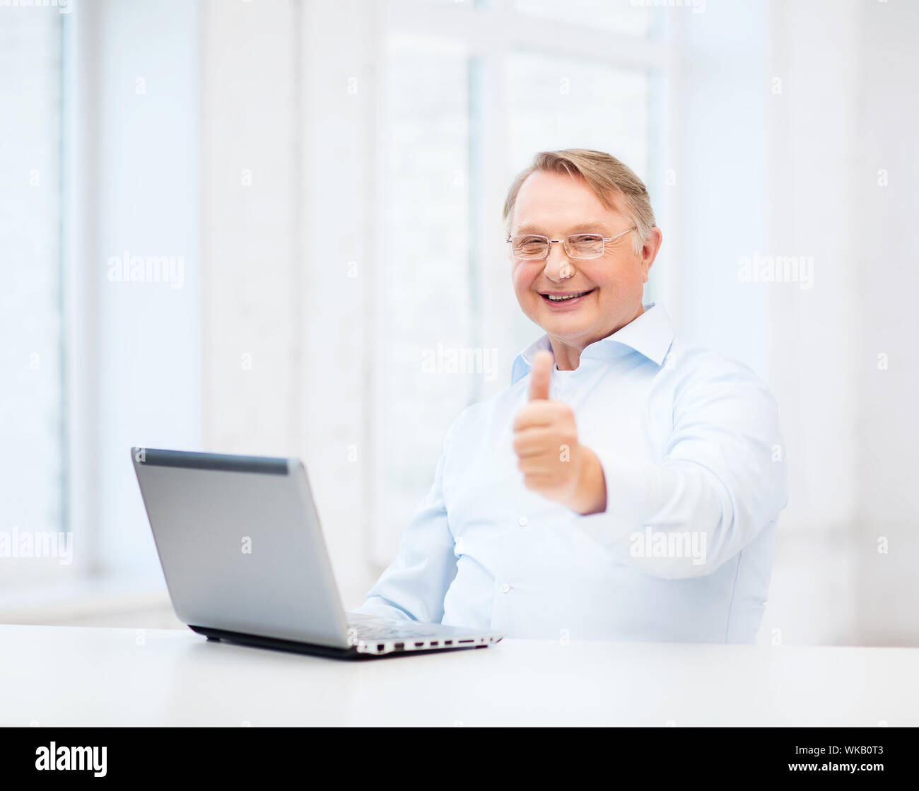 old man with laptop computer showing thumbs up Stock Photo - Alamy