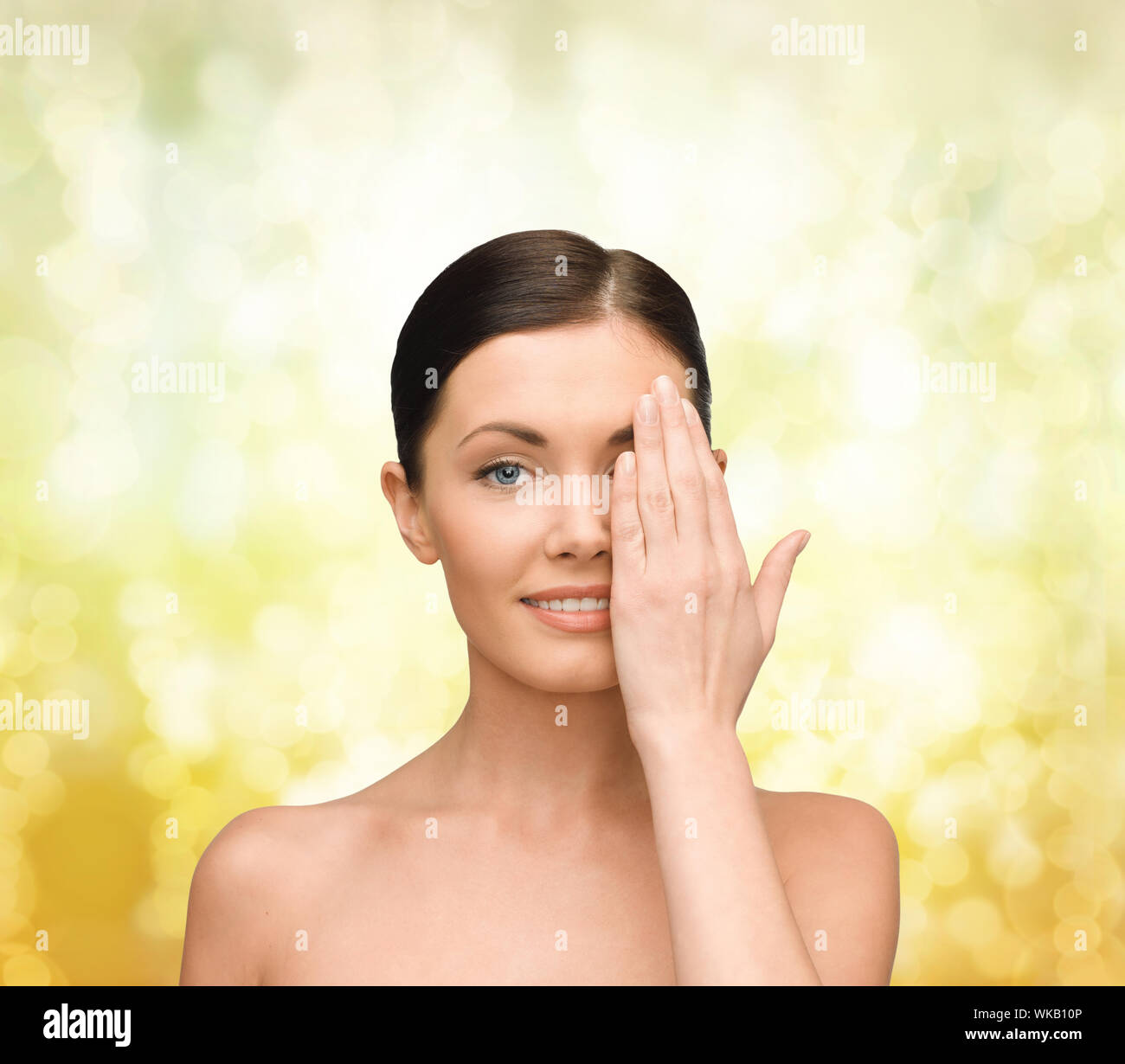 smiling young woman covering face with hand Stock Photo - Alamy