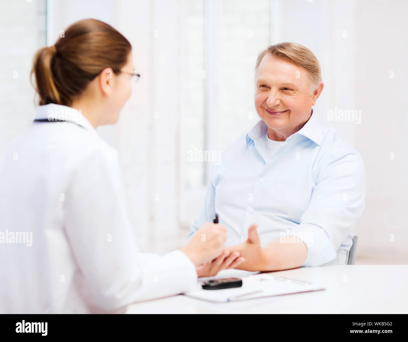 female doctor or nurse measuring blood sugar value Stock Photo - Alamy