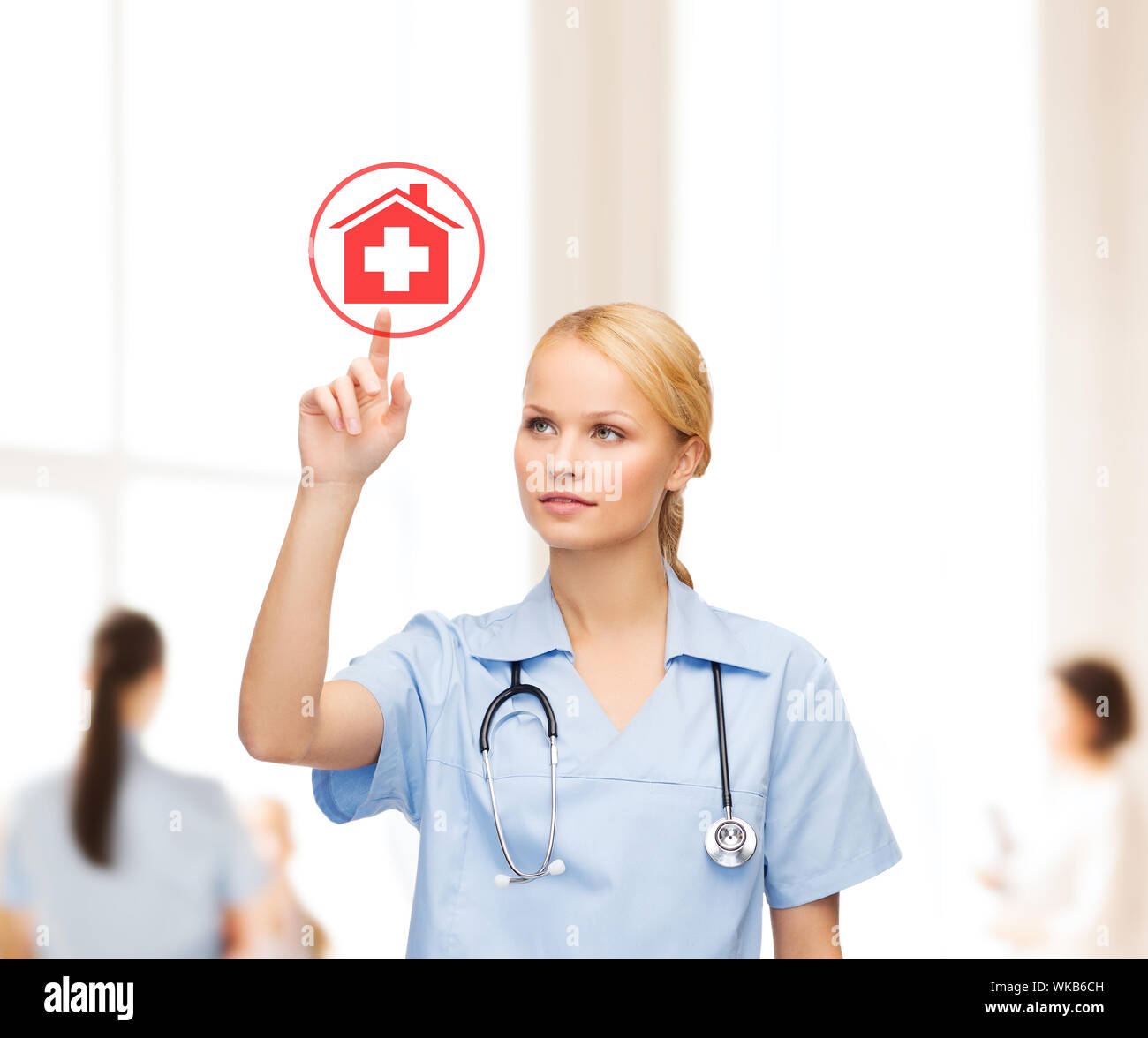 smiling doctor or nurse pointing to hospital icon Stock Photo - Alamy