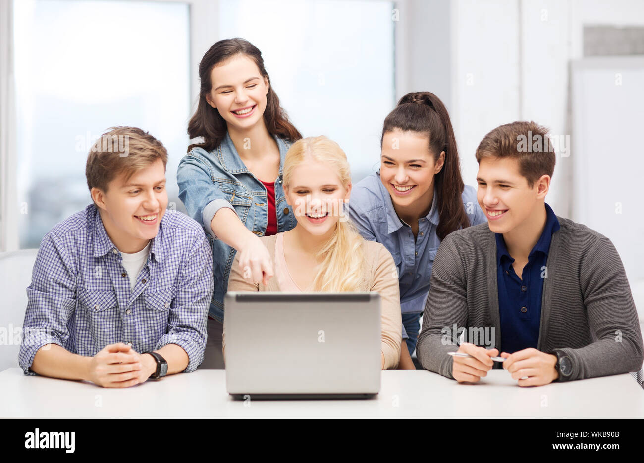 smiling students looking at laptop at school Stock Photo - Alamy