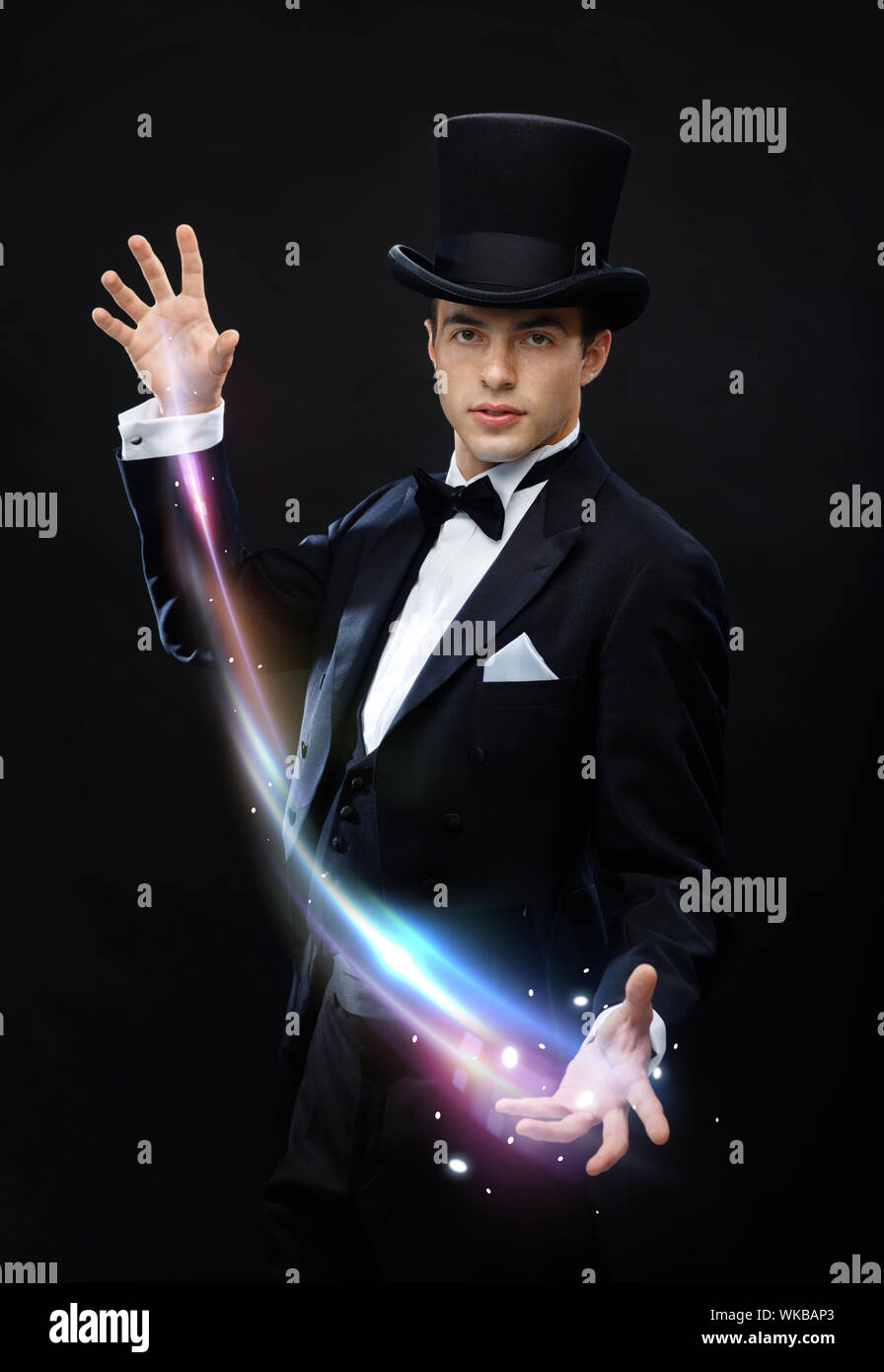 magic, performance, circus, show concept - magician in top hat showing ...
