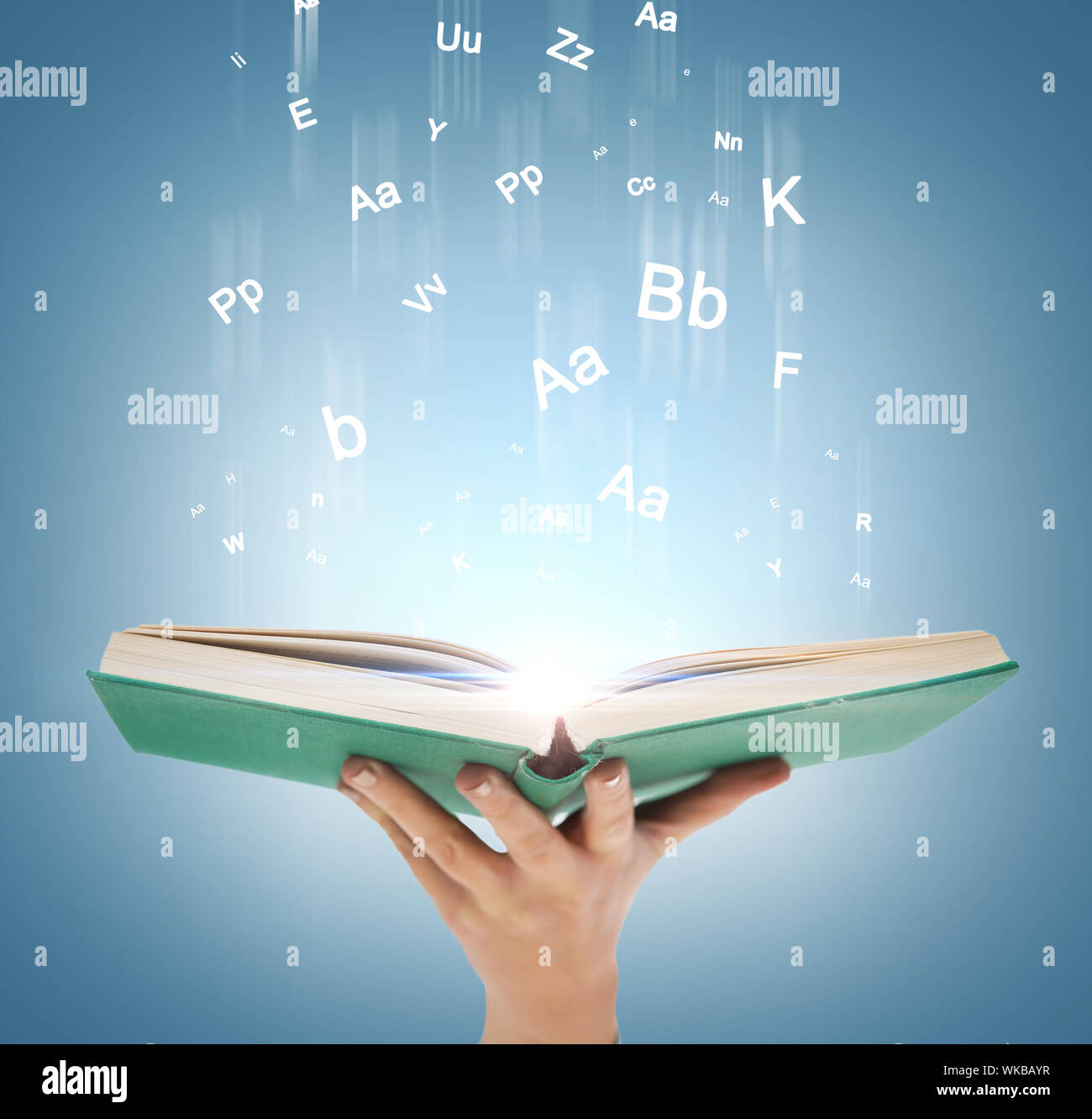 education and book concept - close up hand holding open book with magic ...