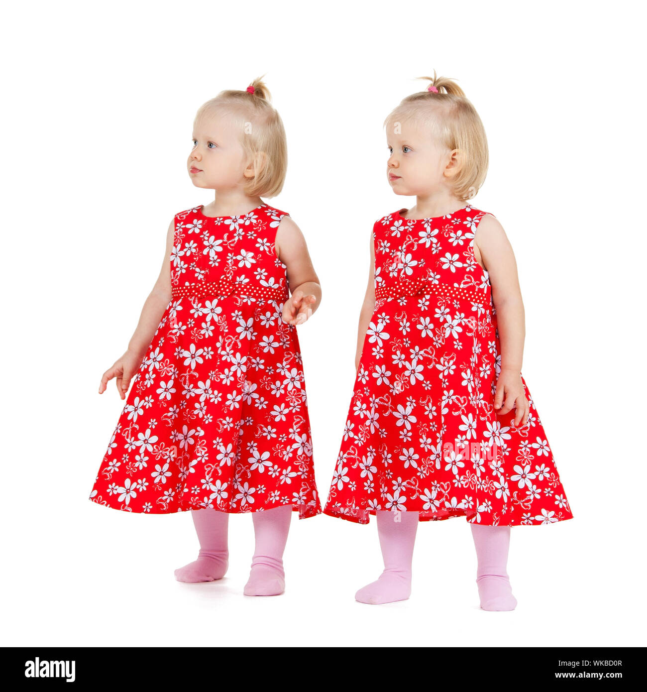 children and twins concept - two identical twin girls in red dresses ...