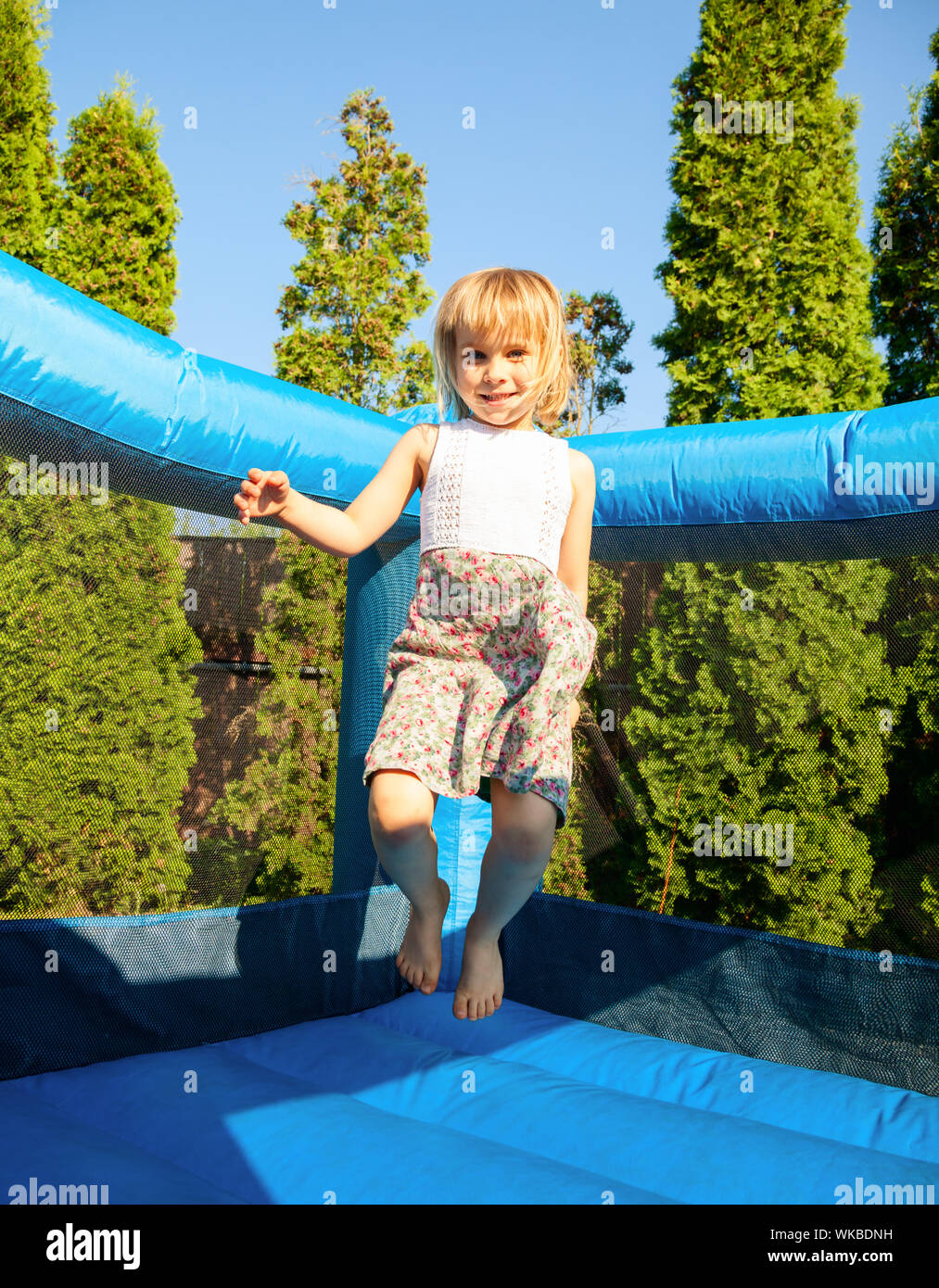 Happy girl jumping on inflatable playground Stock Photo - Alamy