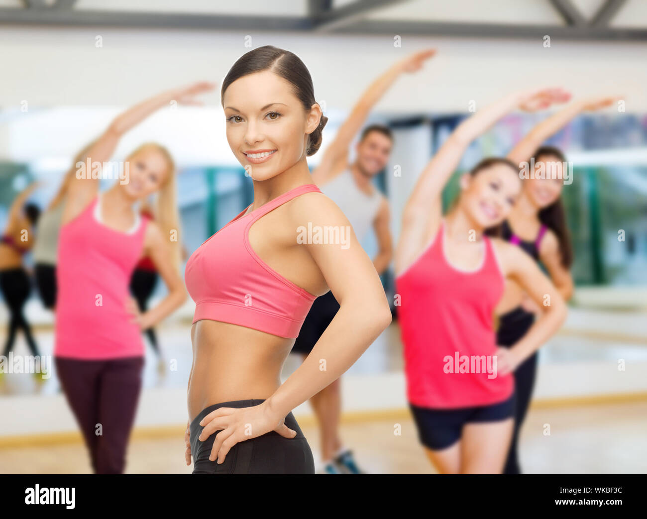 personal trainer with group in gym Stock Photo - Alamy