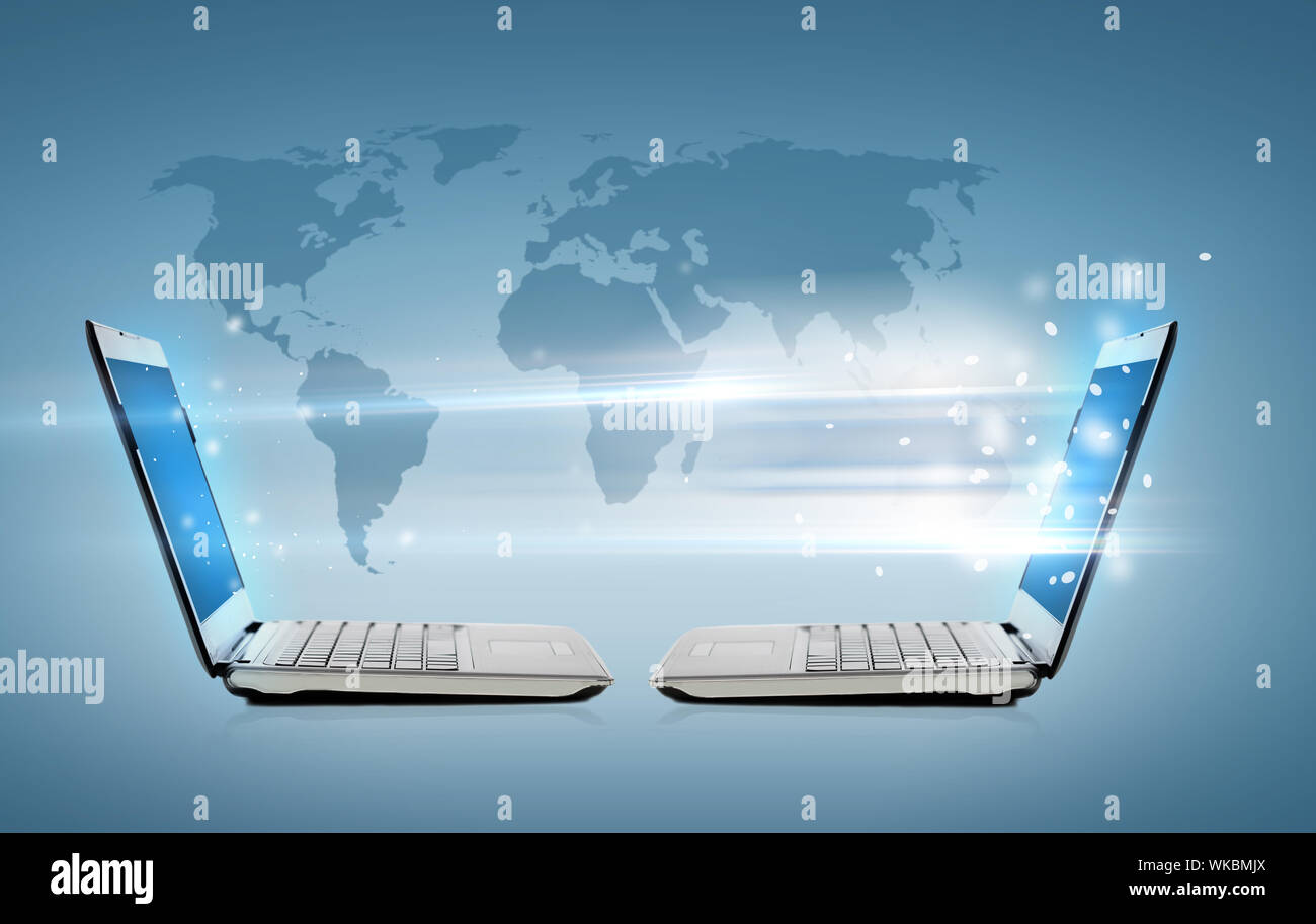 two laptop computers with world map hologram Stock Photo - Alamy