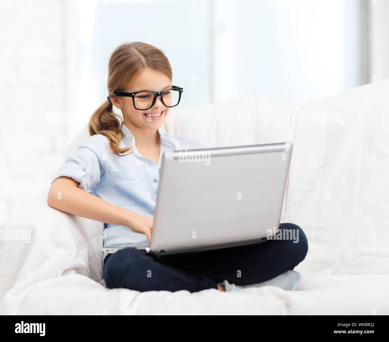 smiling girl in specs with laptop computer at home Stock Photo - Alamy