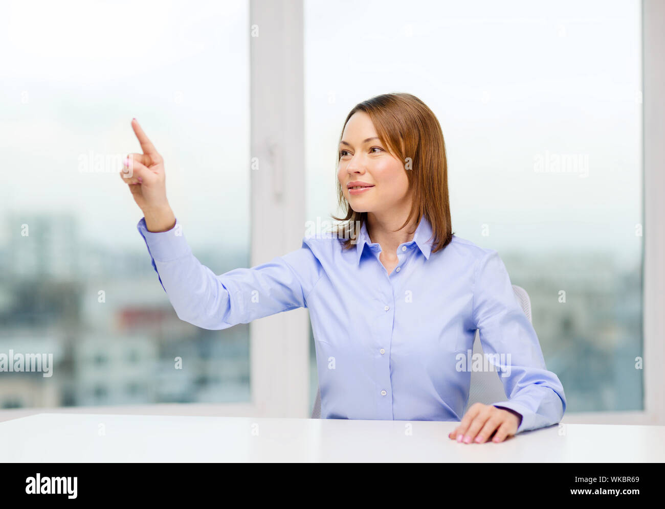 business, education and technology concept - smiling woman pointing to ...