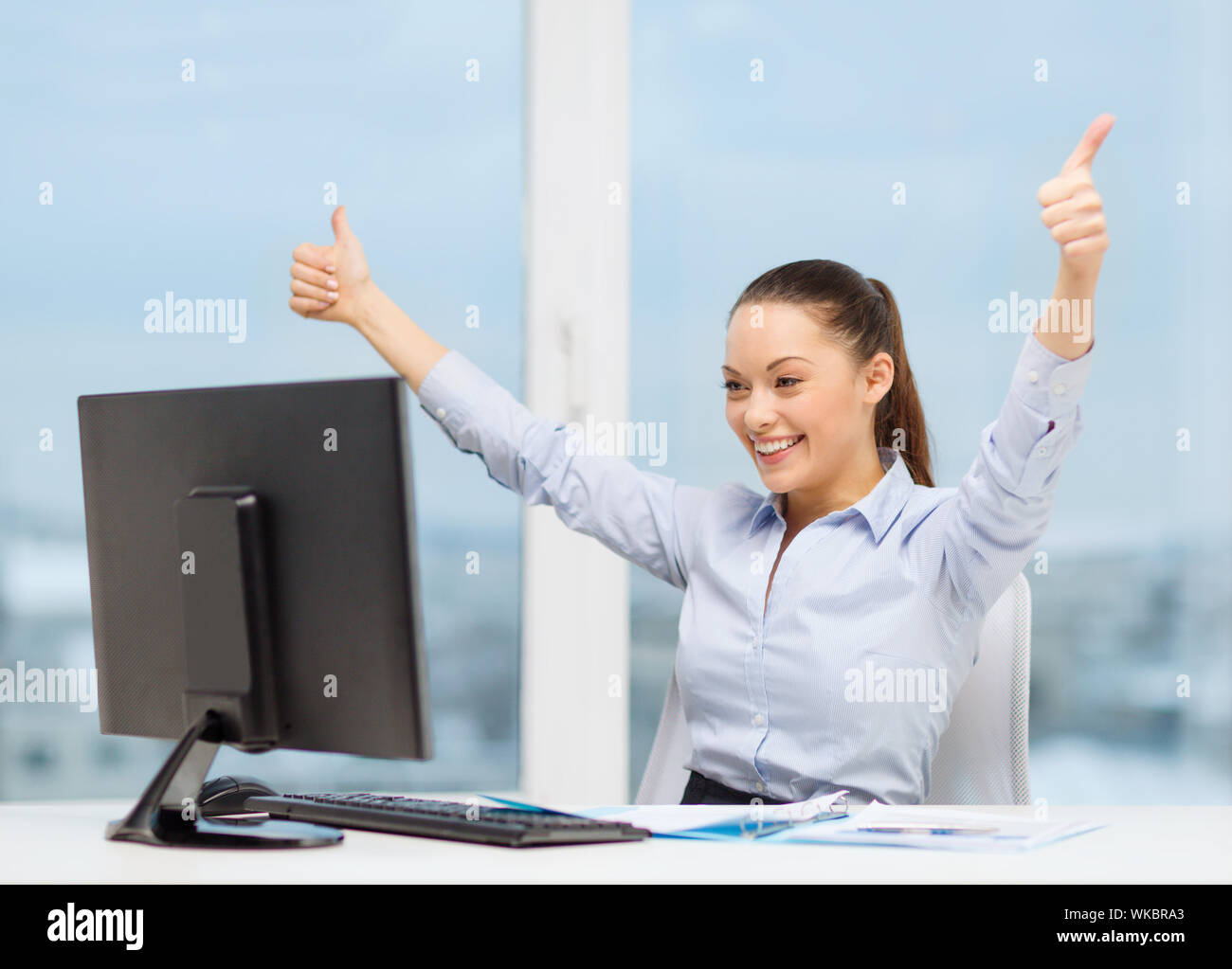 woman with computer, papers showing thumbs up Stock Photo - Alamy