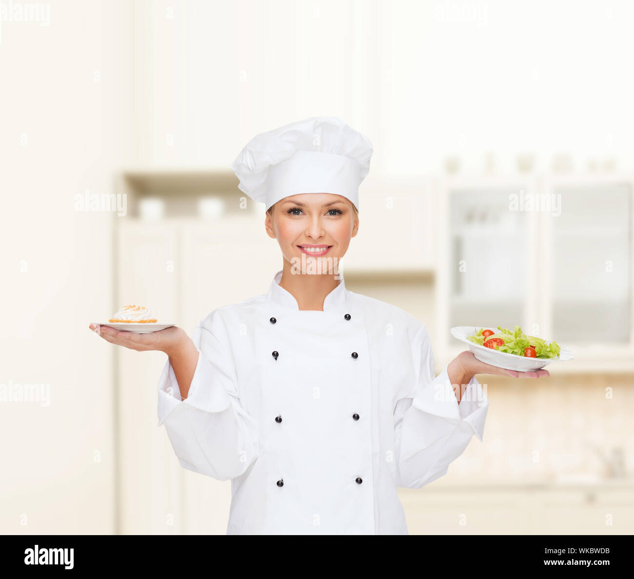 smiling female chef with salad and cake on plates Stock Photo - Alamy