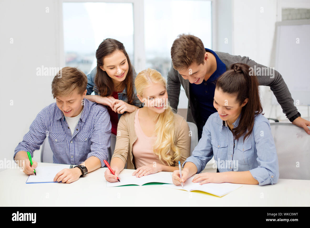 school and education concept - group of smiling students with notebooks ...