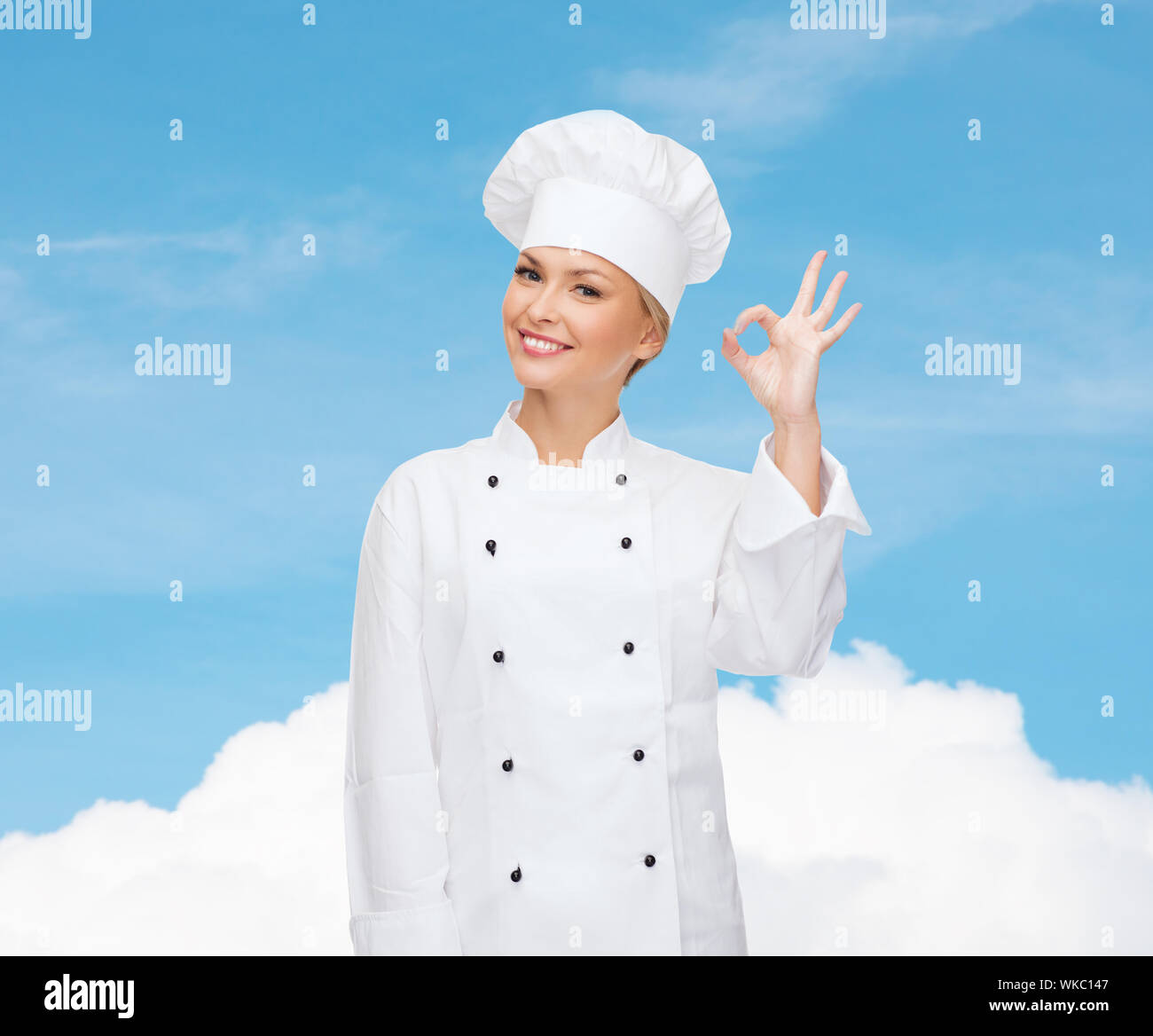 smiling female chef showing ok hand sign Stock Photo - Alamy