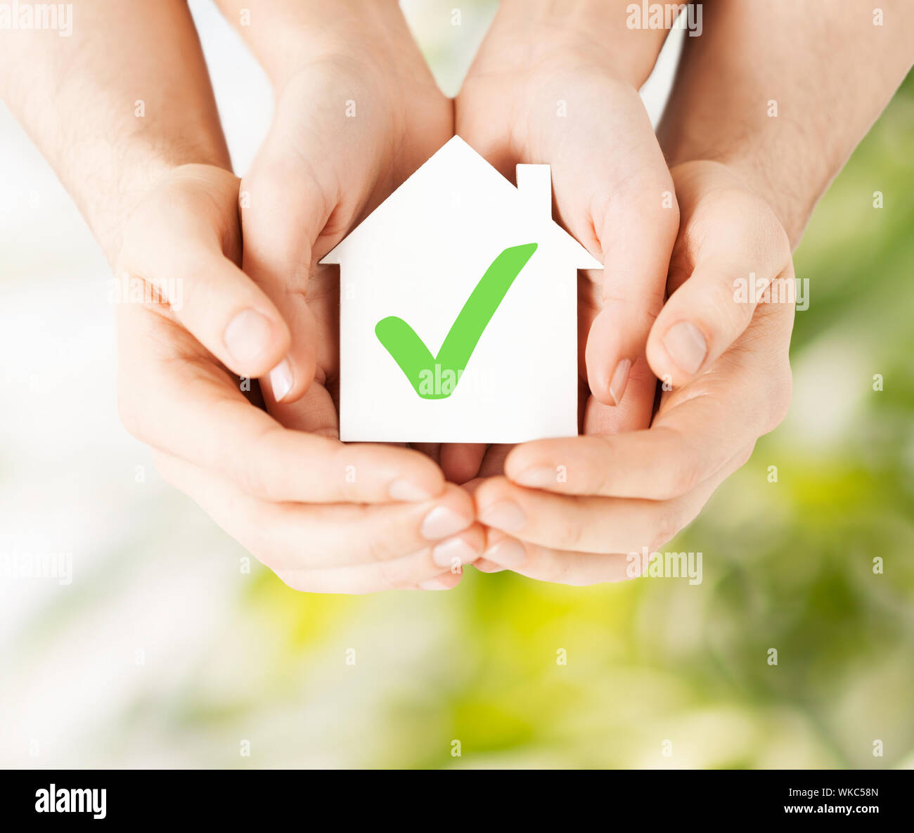 hands holding house with check mark Stock Photo - Alamy