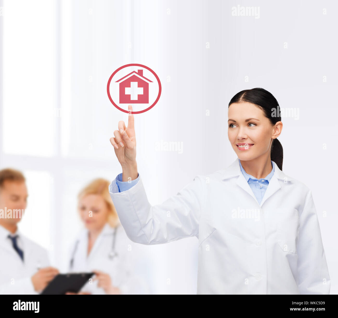 smiling female doctor pointing to hospital sign Stock Photo - Alamy