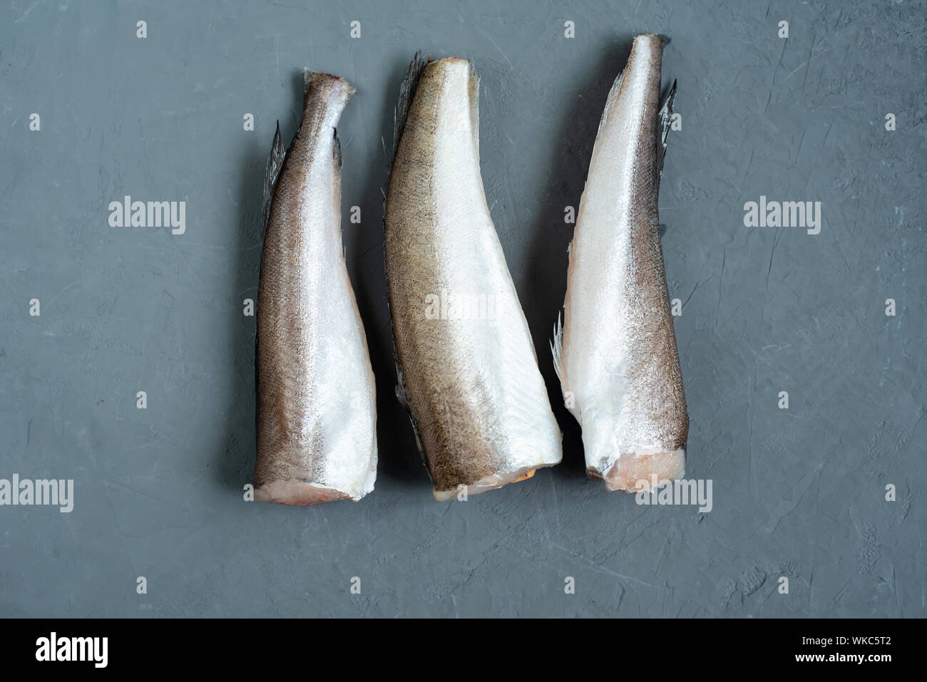 Raw fish hake. Five Raw fish fillet on grey background, food background ...