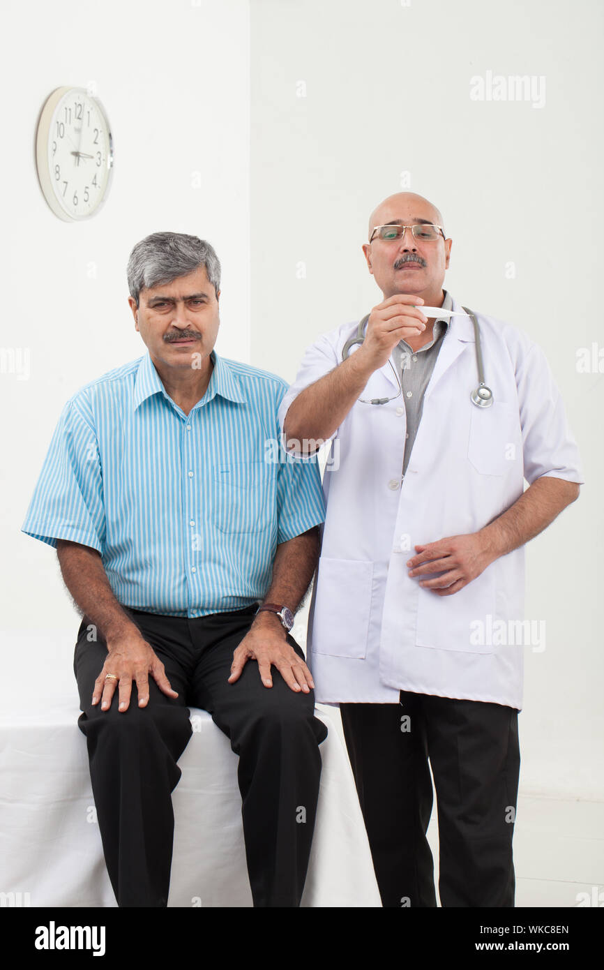Male doctor checking his patient,s temperature Stock Photo - Alamy