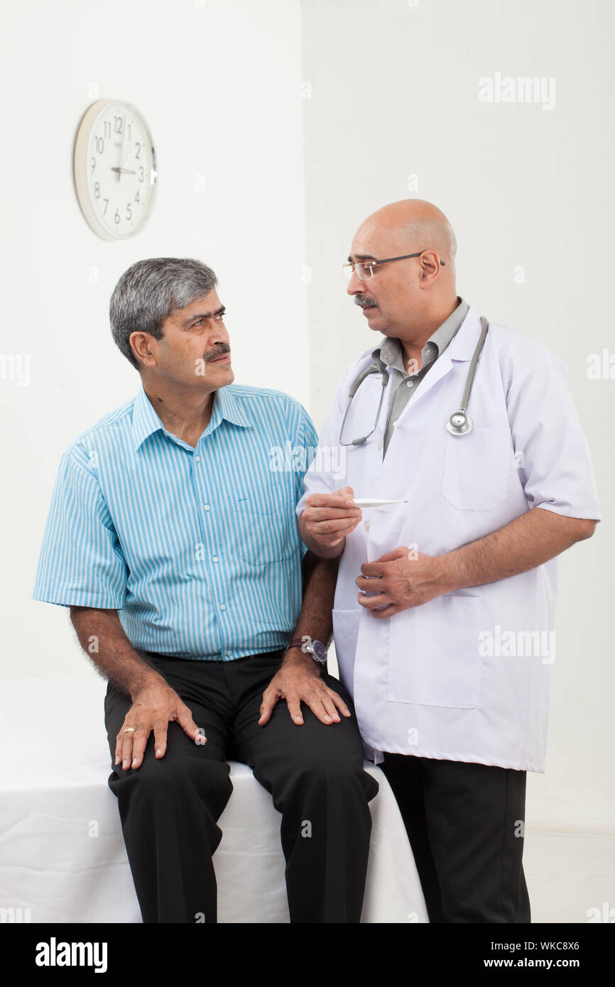 Male doctor checking his patient,s temperature Stock Photo - Alamy