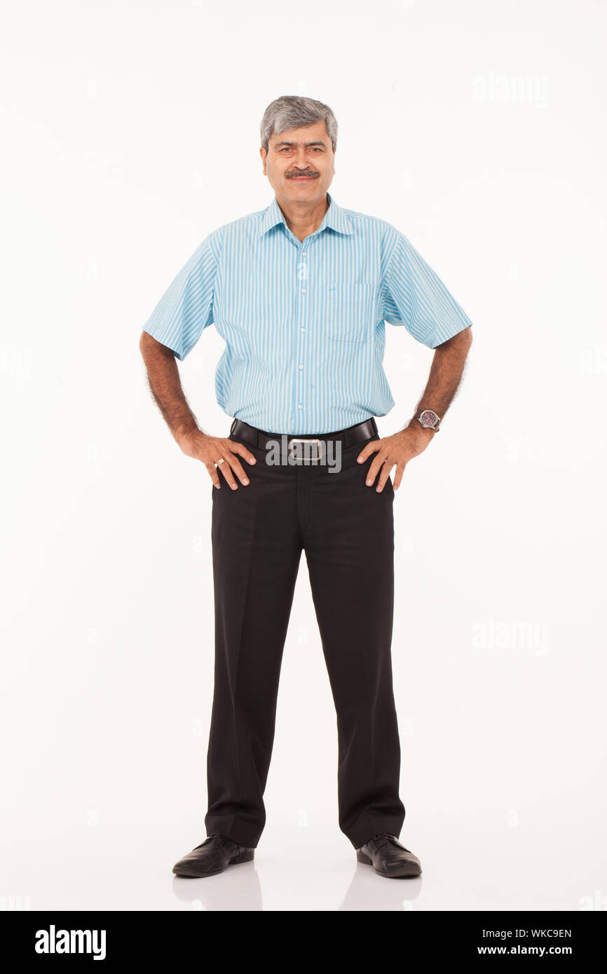 Man standing with arms akimbo Stock Photo - Alamy