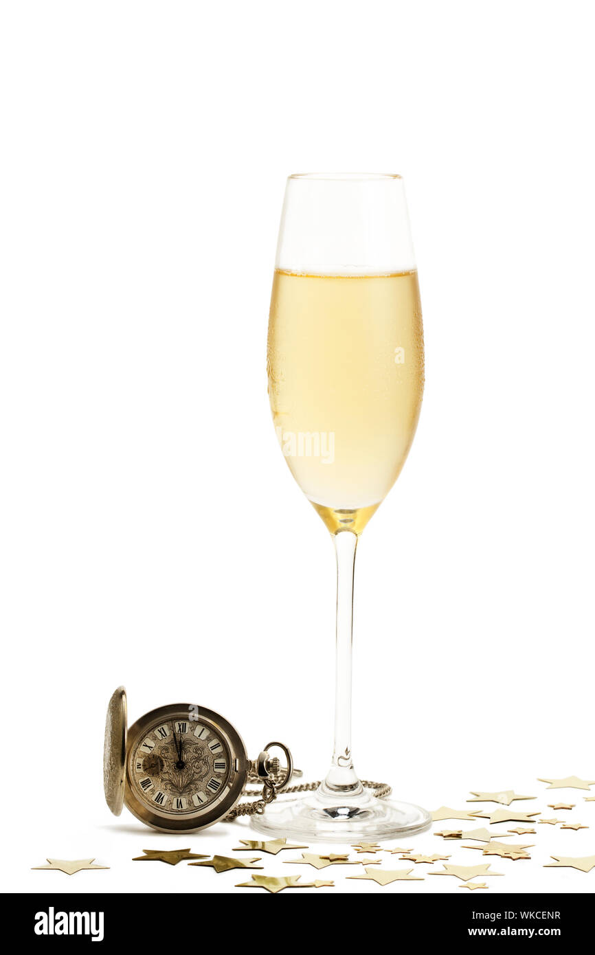 cold glass of champagne with a old pocket watch and metal stars on ...