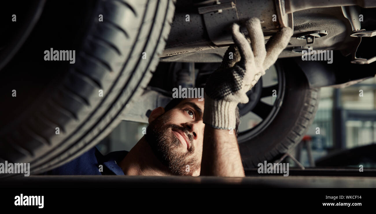 Mechatronics engineer examining the exhaust of a car in the car ...