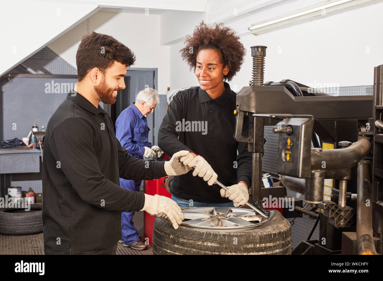 African woman as mechanic apprentice at tire assembly in auto repair ...