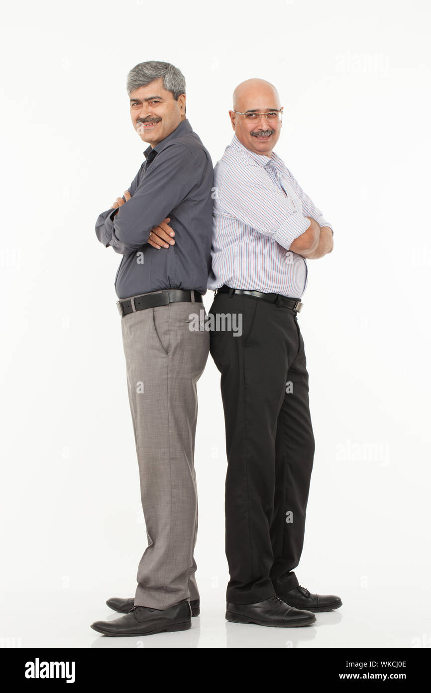 Two business executives standing back to back with his arms crossed ...