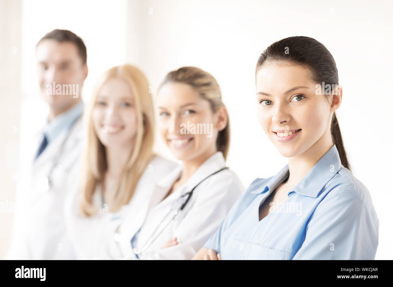 attractive female doctor or nurse in front of medical group Stock Photo ...