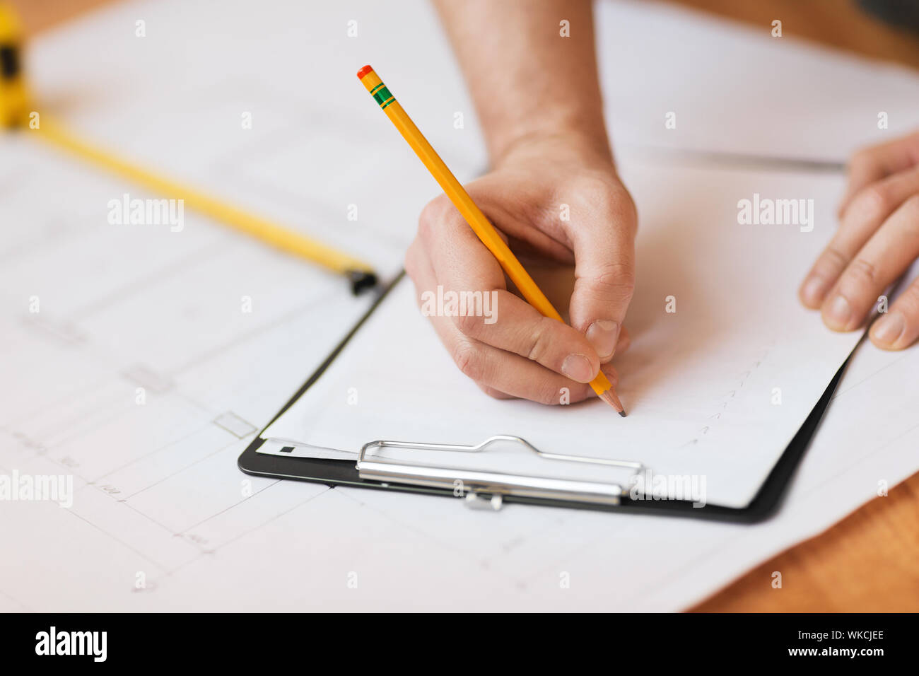 repair, building and home concept - close up of male hands writing in ...