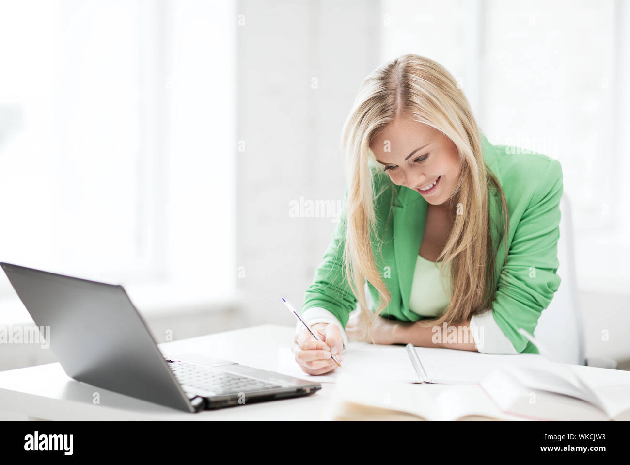 education concept - picture of smiling student girl writing in notebook ...
