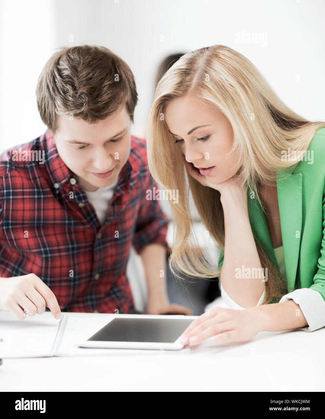 education concept - picture of students looking at tablet pc at school ...