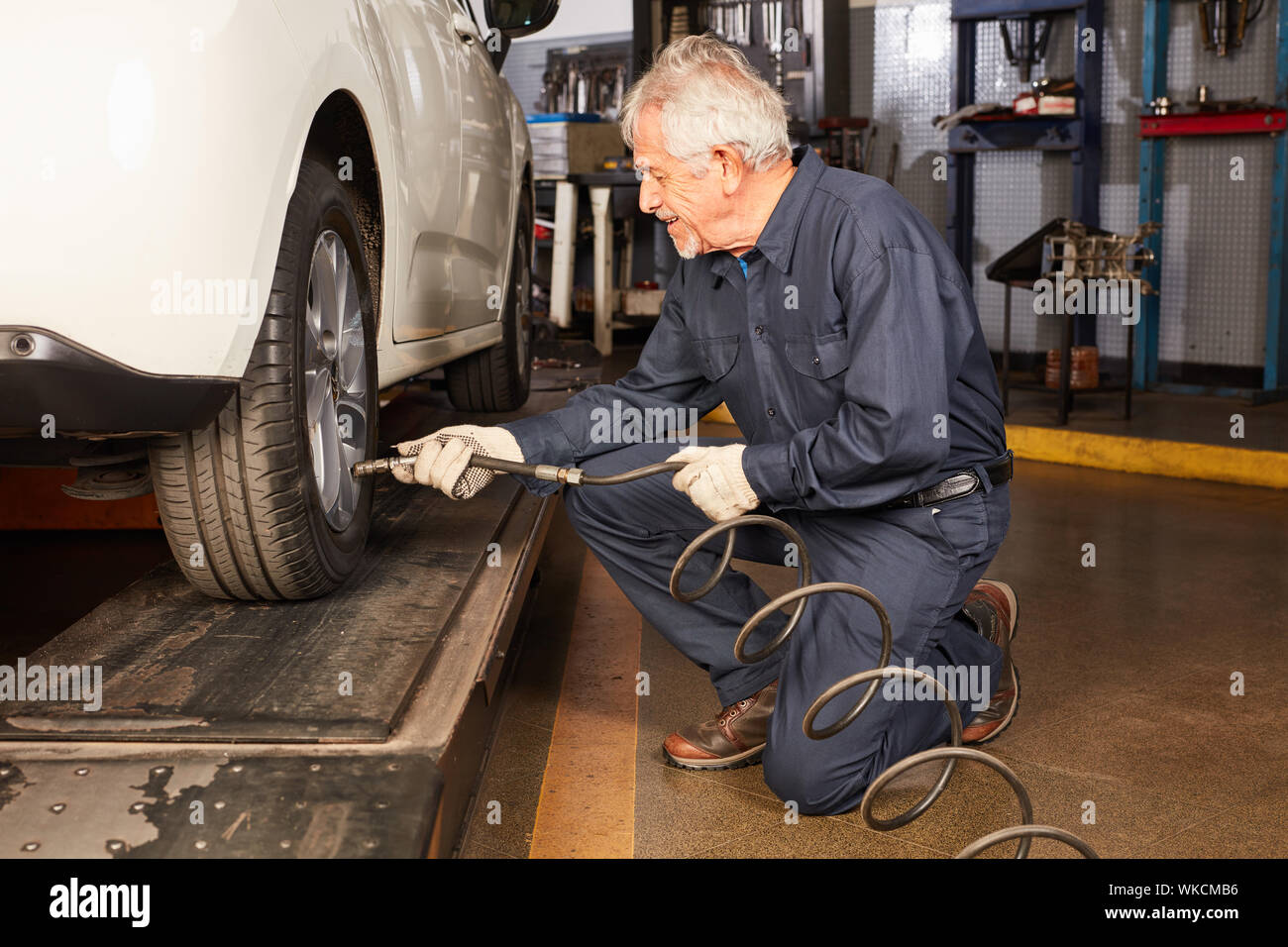 Experienced mechanic at the wheel changing the car in the workshop or ...