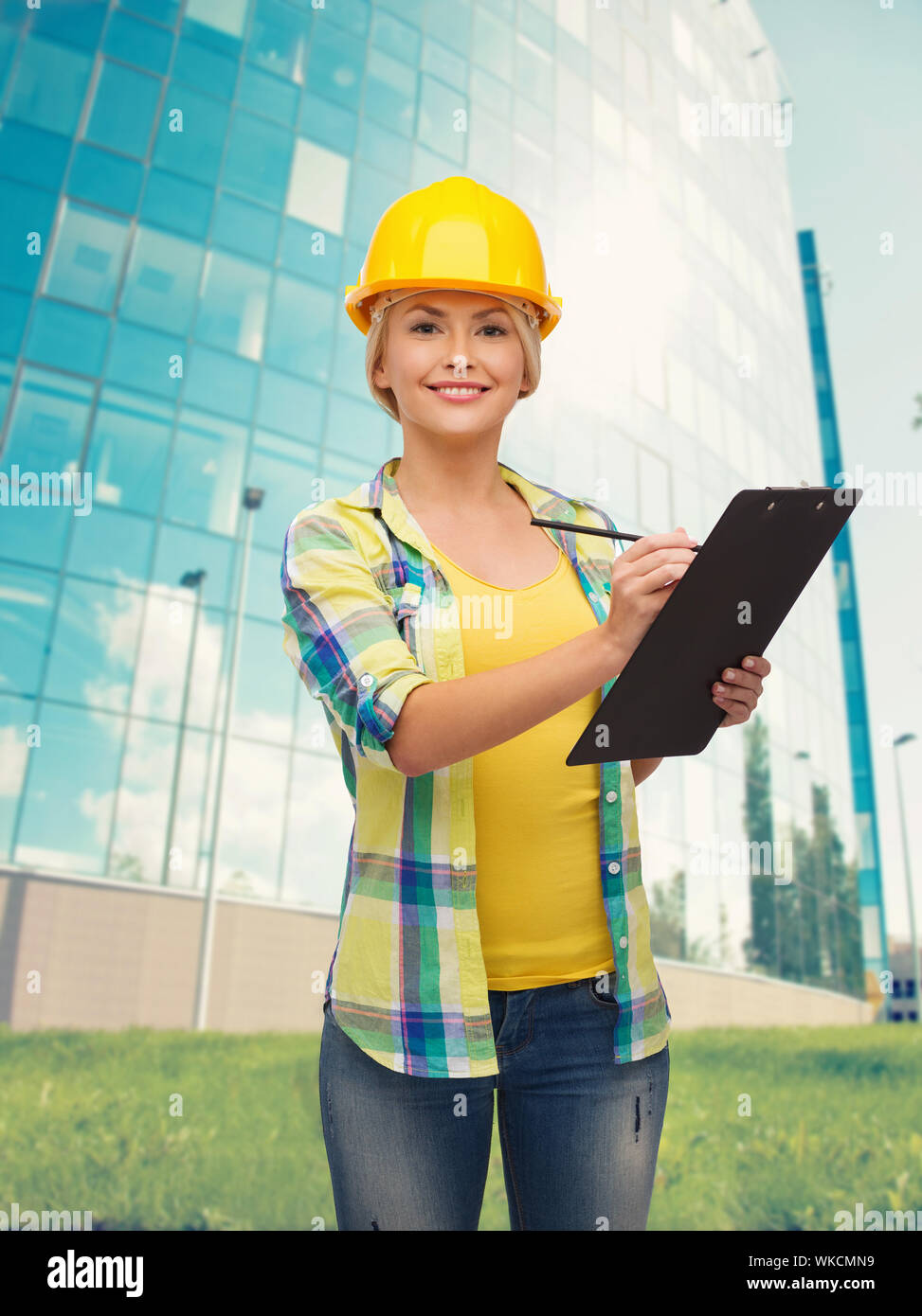repair, construction and maintenance concept - smiling woman in helmet ...