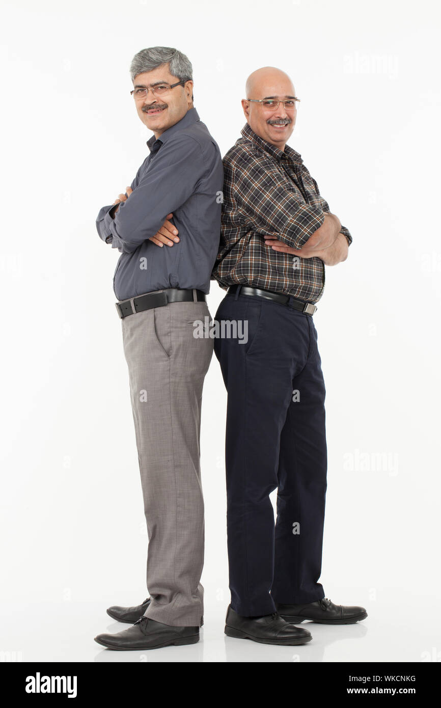Portrait of two businessmen standing back to back Stock Photo - Alamy