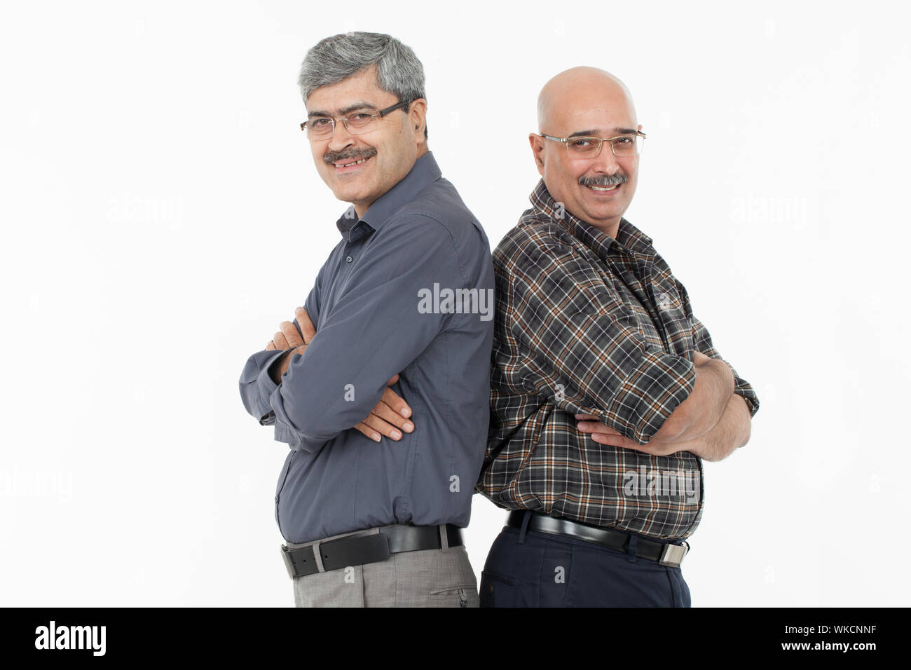 Portrait of two businessmen standing back to back Stock Photo - Alamy