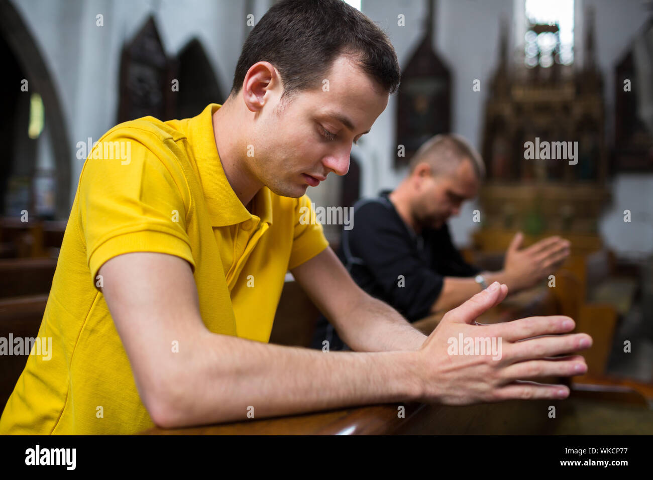 Handsome young man praying in a church Stock Photo - Alamy