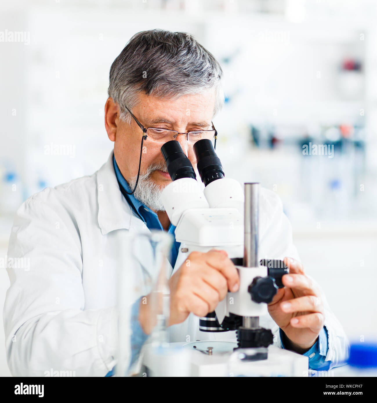 Senior male researcher carrying out scientific research in a lab using ...