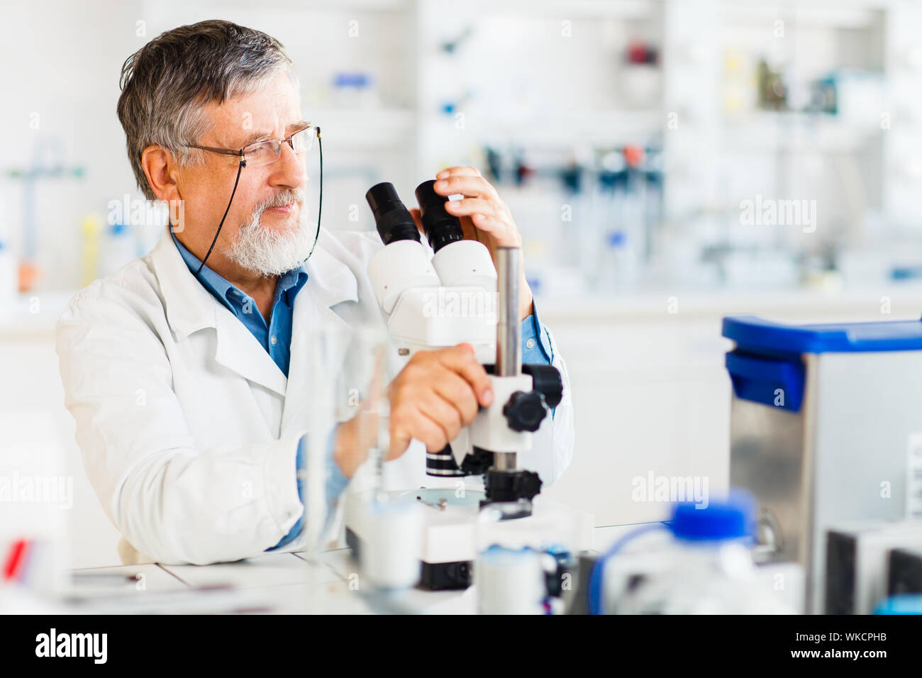 Senior male researcher carrying out scientific research in a lab using ...