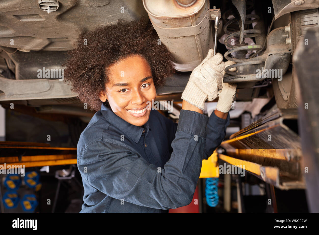 Smiling African car mechanic repairing or inspecting car Stock Photo ...