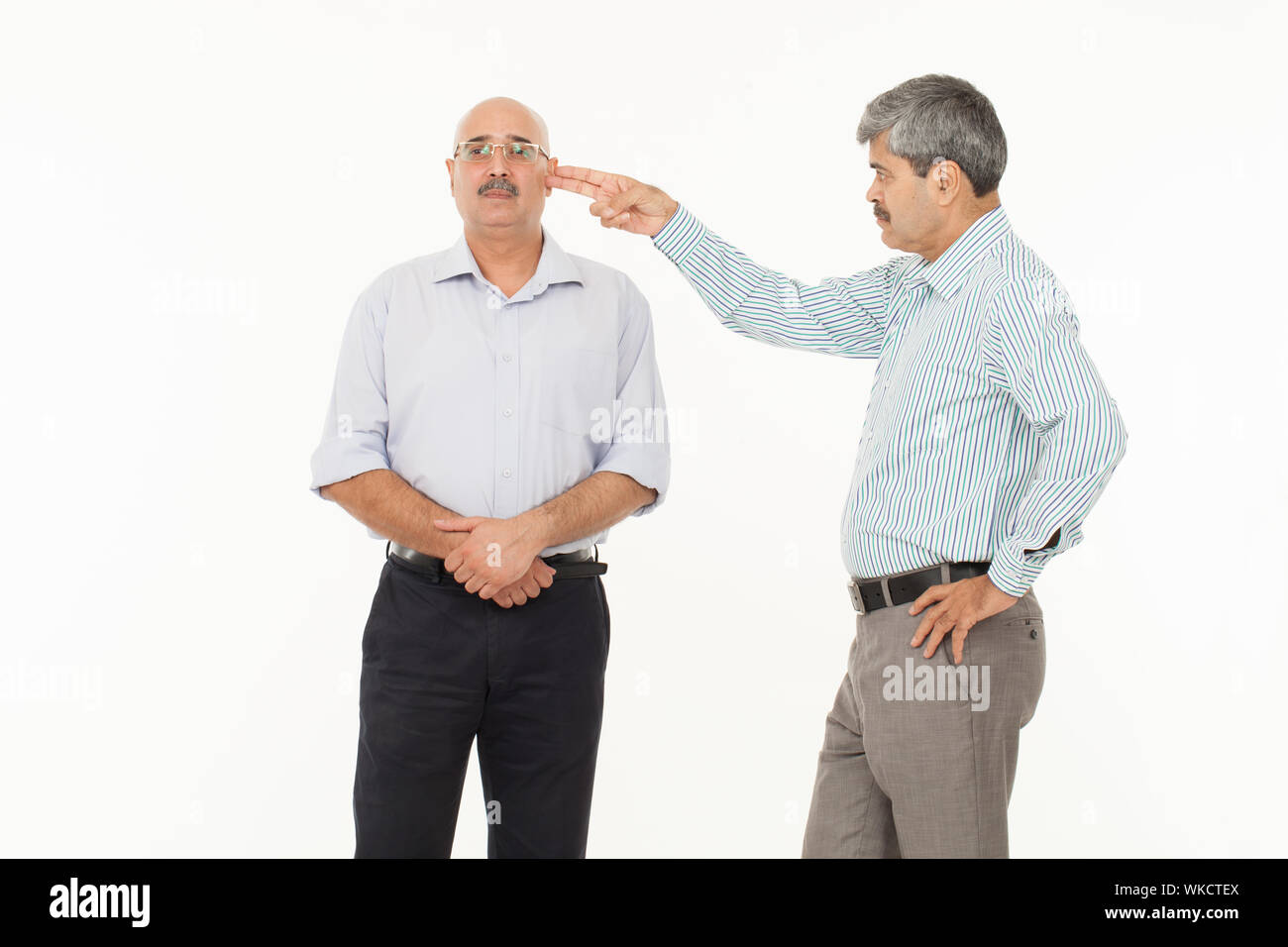 Businessman pointing finger gun to his employee Stock Photo - Alamy