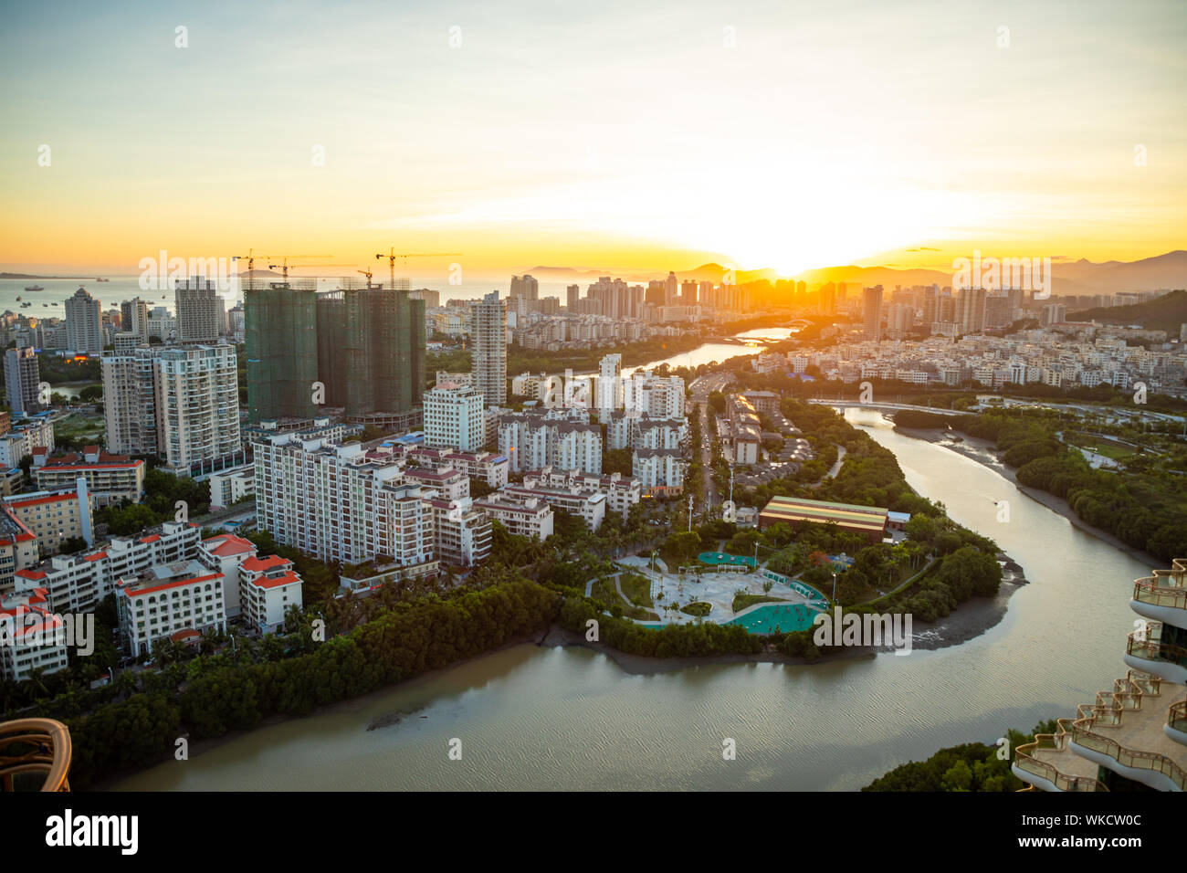 Aerial view of Sanya city with river at sunset light in Hainan province ...