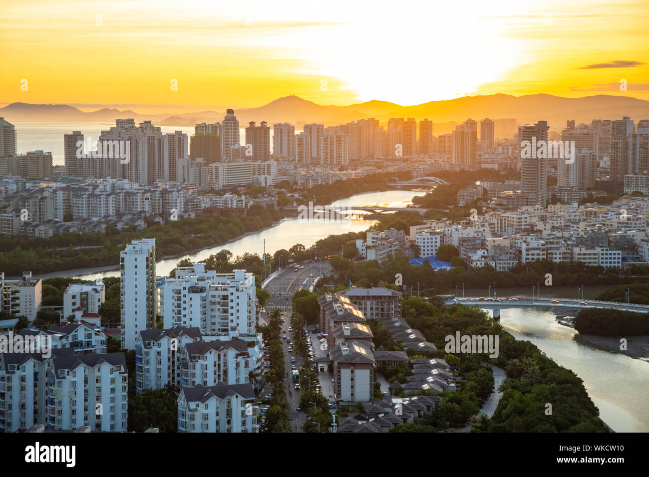 Aerial view of Sanya city with river at sunset light in Hainan province ...
