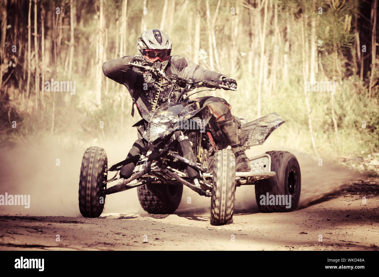 ATV racer takes a turn during a race on a dusty terrain Stock Photo - Alamy