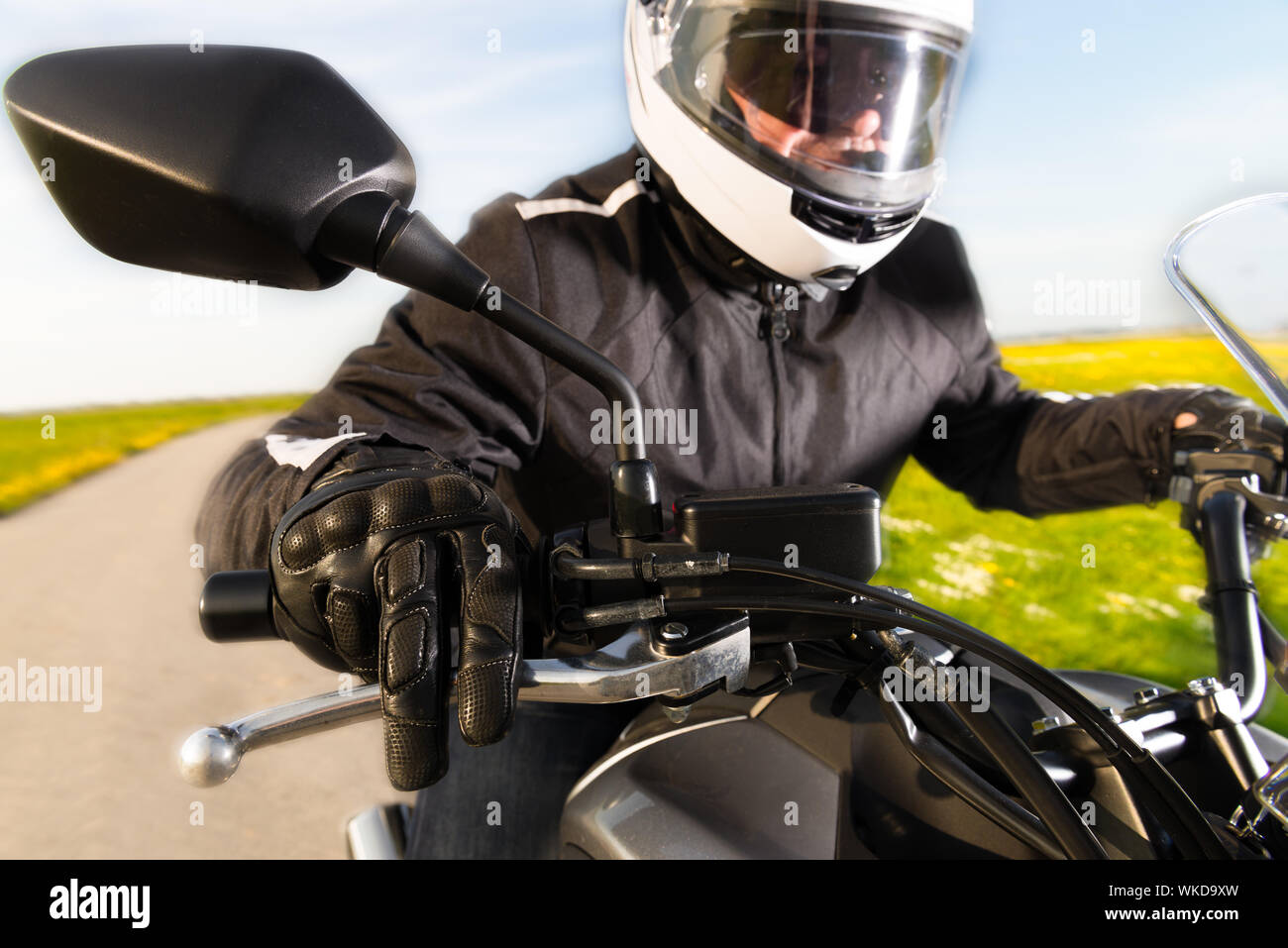 Biker in helmet and leather jacket riding on the road Stock Photo - Alamy