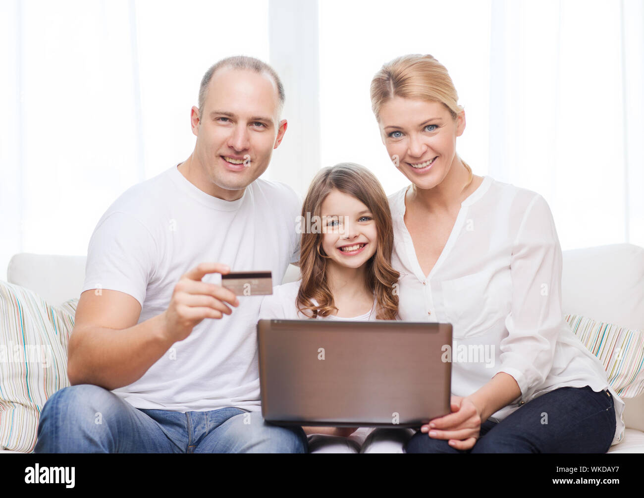 parents and girl with laptop and credit card Stock Photo - Alamy