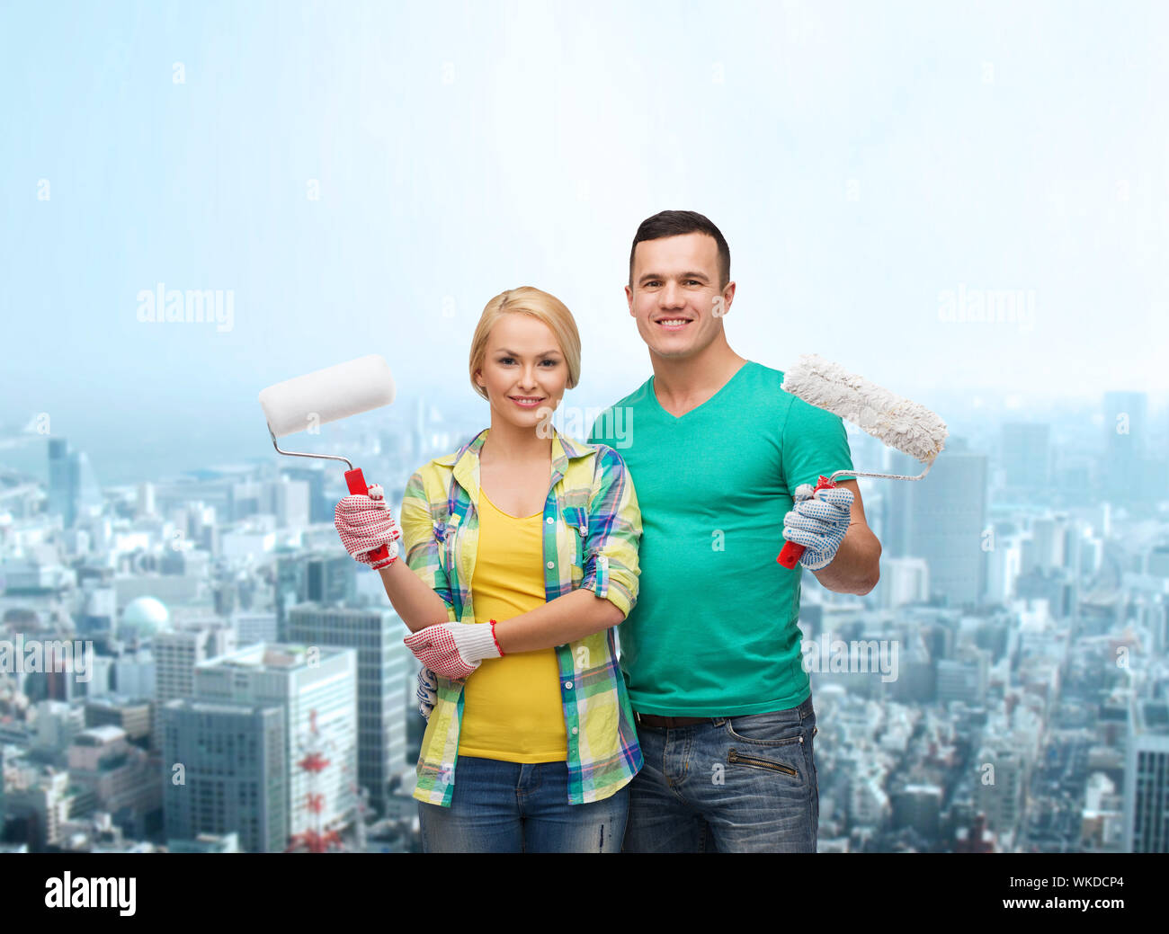 repair, construction and maintenance concept - smiling couple in gloves ...