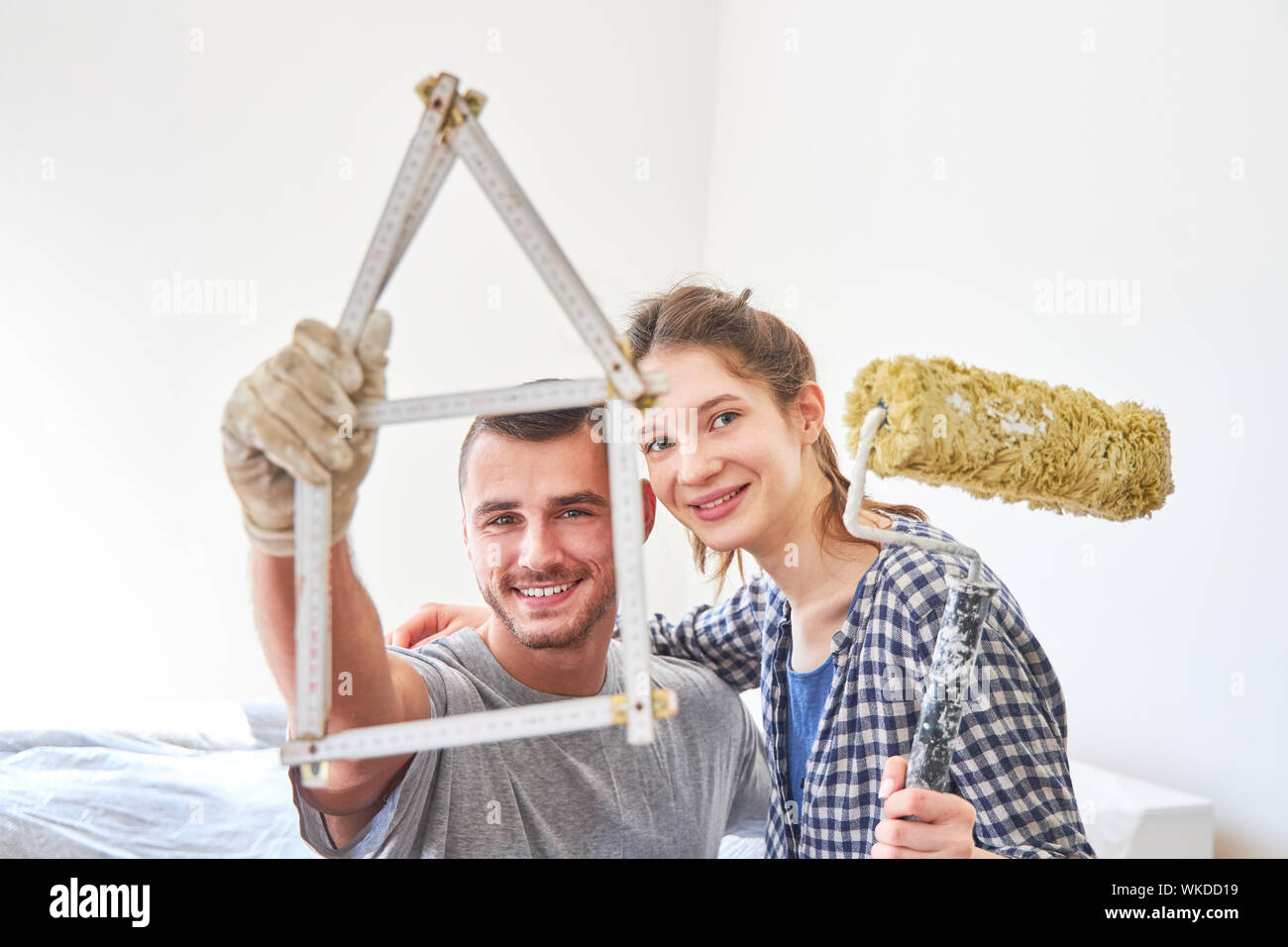 Happy young handyman couple renovating in new home as a dream house ...