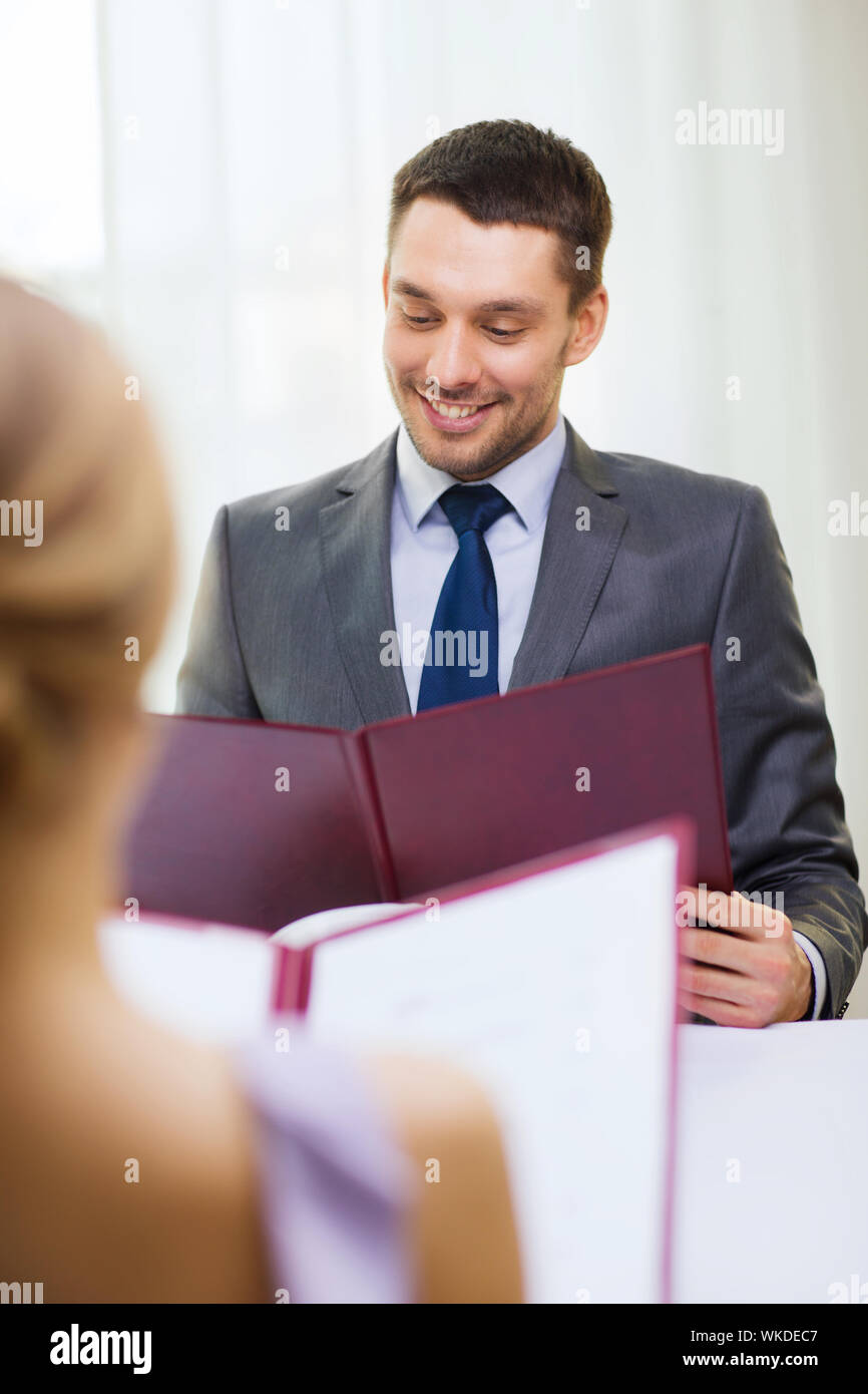 restaurant, couple and holiday concept - smiling young man looking at ...